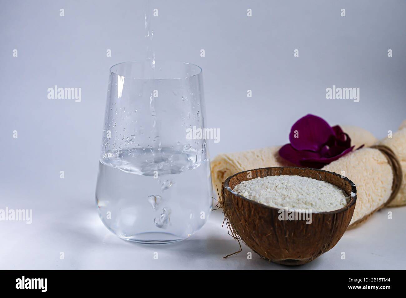 Collagen powder in half coconut with a spoon for measuring quantity ...