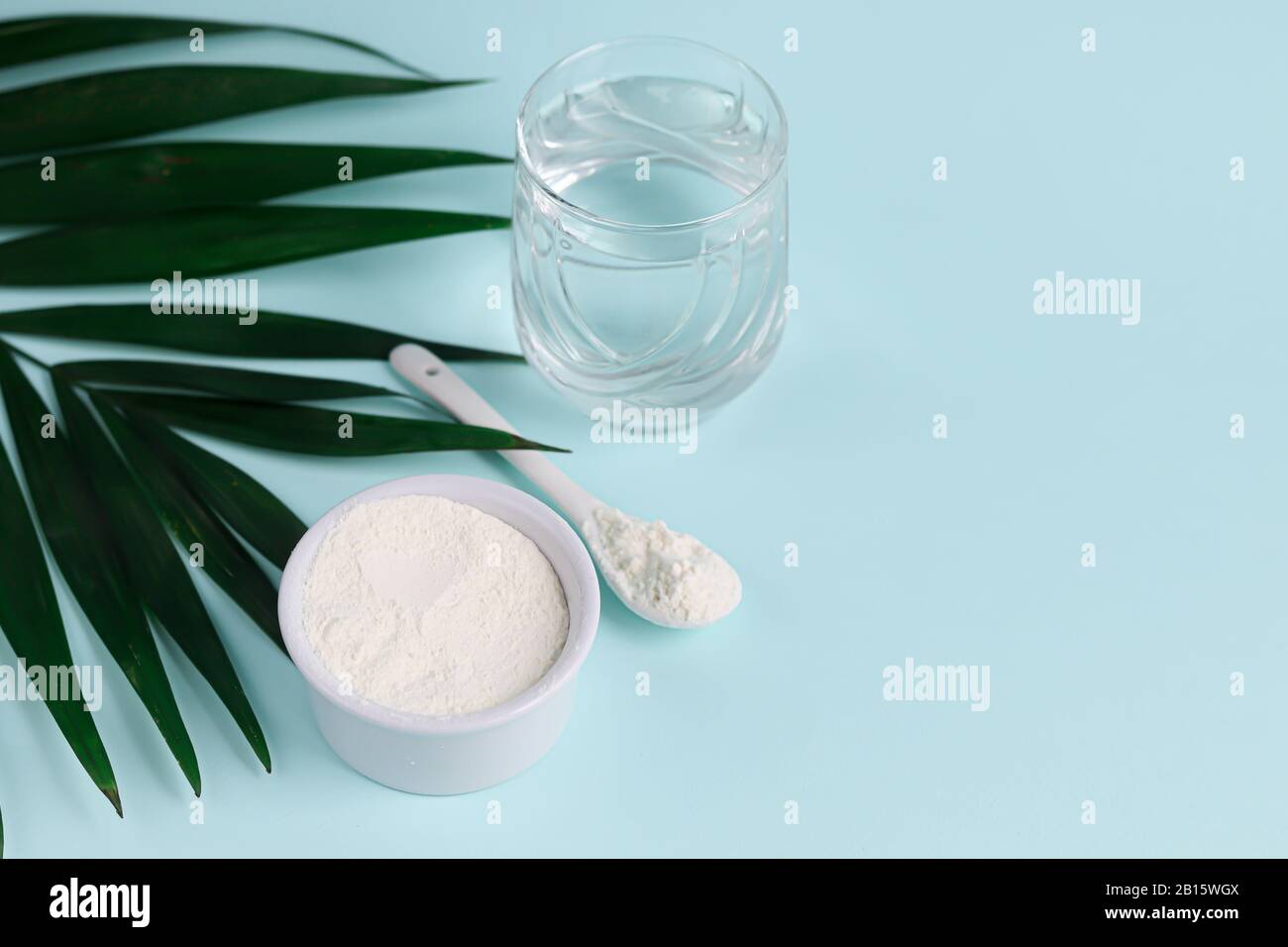 Collagen powder in half coconut with a spoon for measuring quantity ...