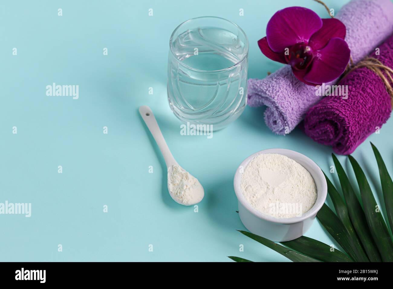 Collagen powder in half coconut with a spoon for measuring quantity ...