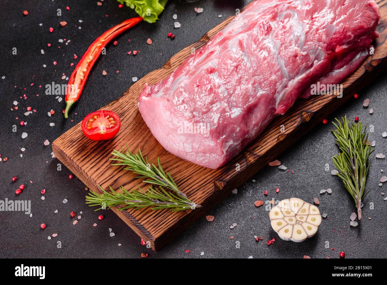 Fresh pieces pork ready to cook on a dark background in the kitchen ...