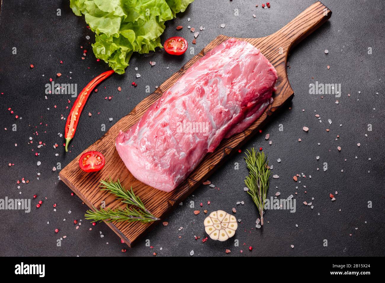 Fresh pieces pork ready to cook on a dark background in the kitchen ...