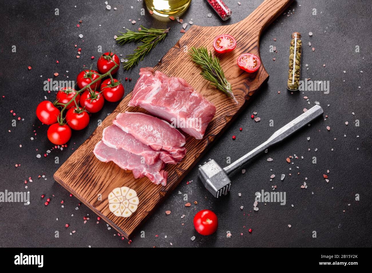 Fresh pieces pork ready to cook on a dark background in the kitchen ...