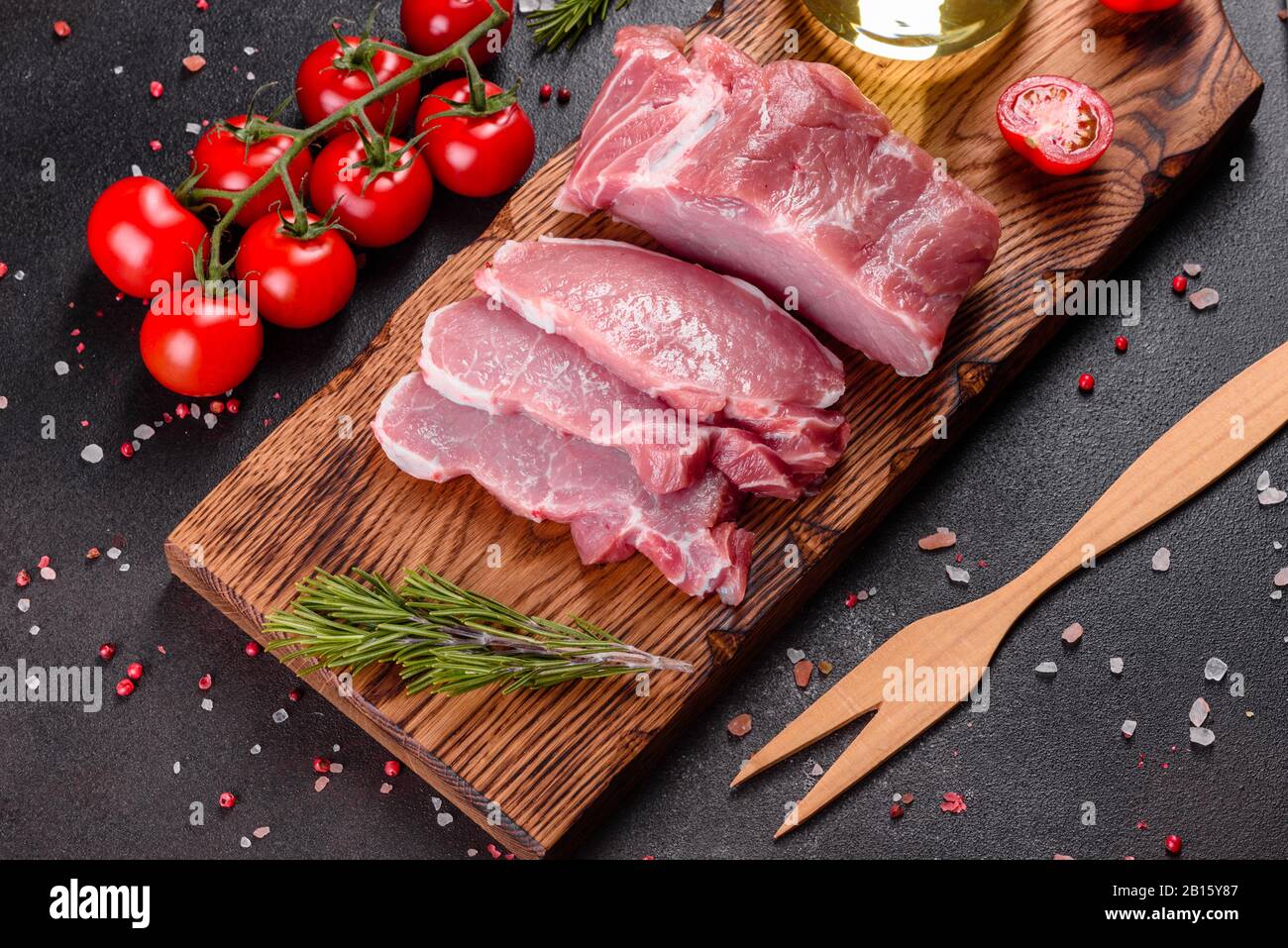 Fresh pieces pork ready to cook on a dark background in the kitchen ...