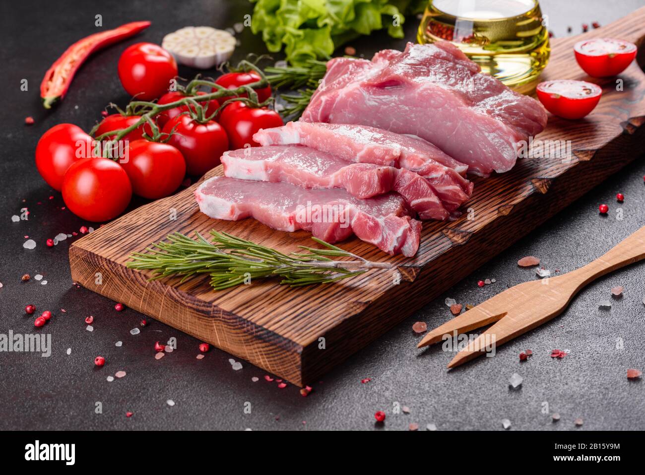 Fresh pieces pork ready to cook on a dark background in the kitchen ...