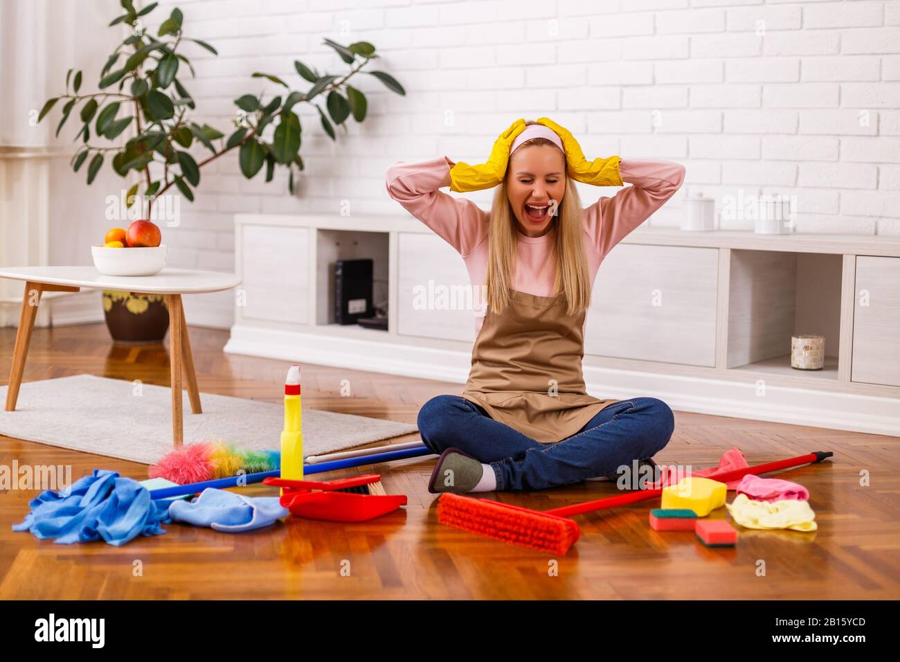 Image of overworked housewife with cleaning equipment shouting while ...
