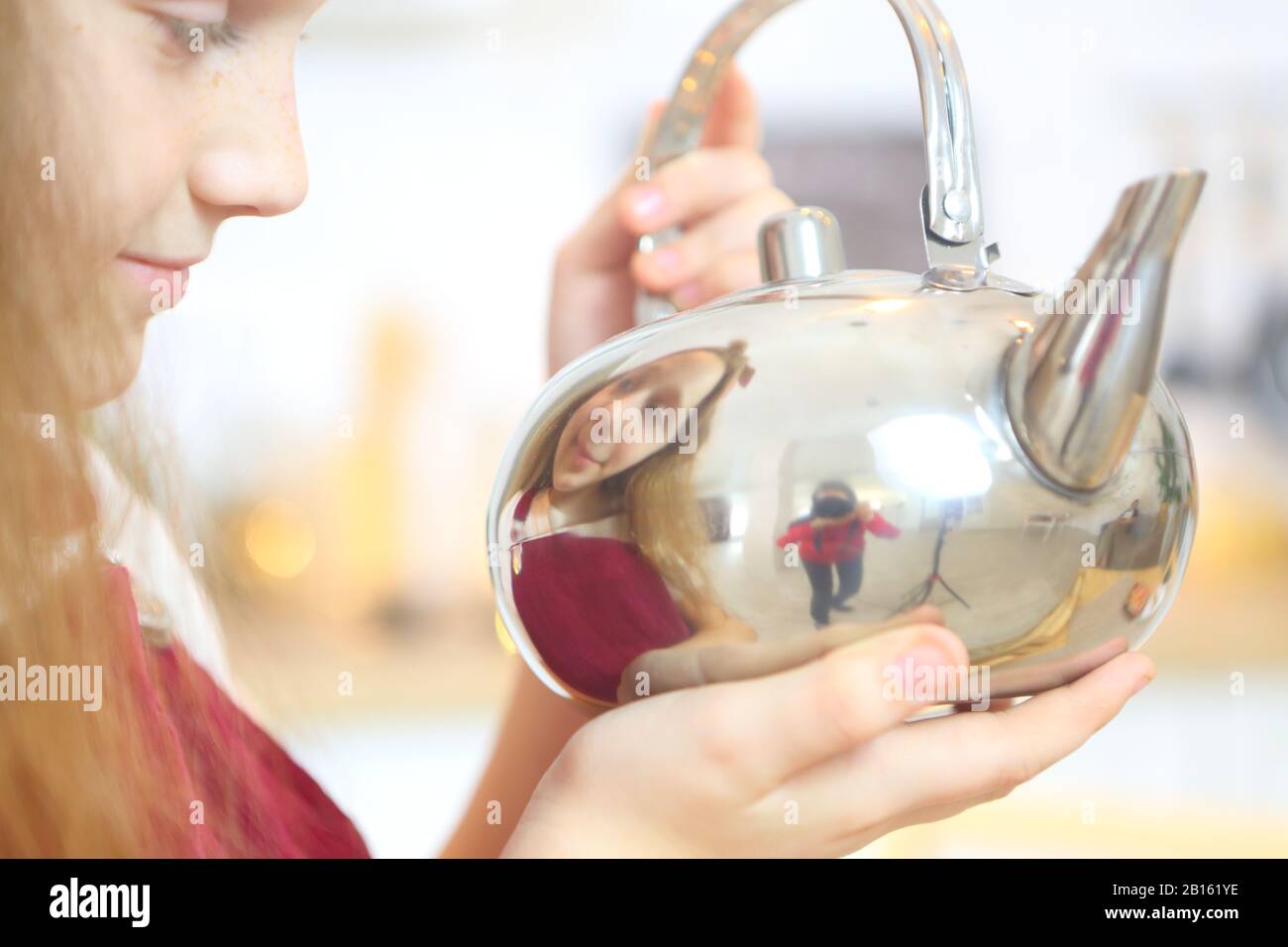 Girl holding a kettle Stock Photo - Alamy