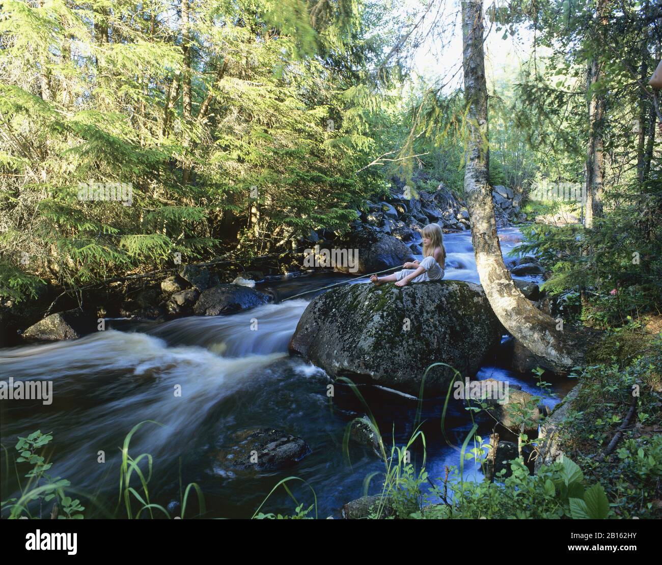 Little girl fishing in forest stream Stock Photo - Alamy
