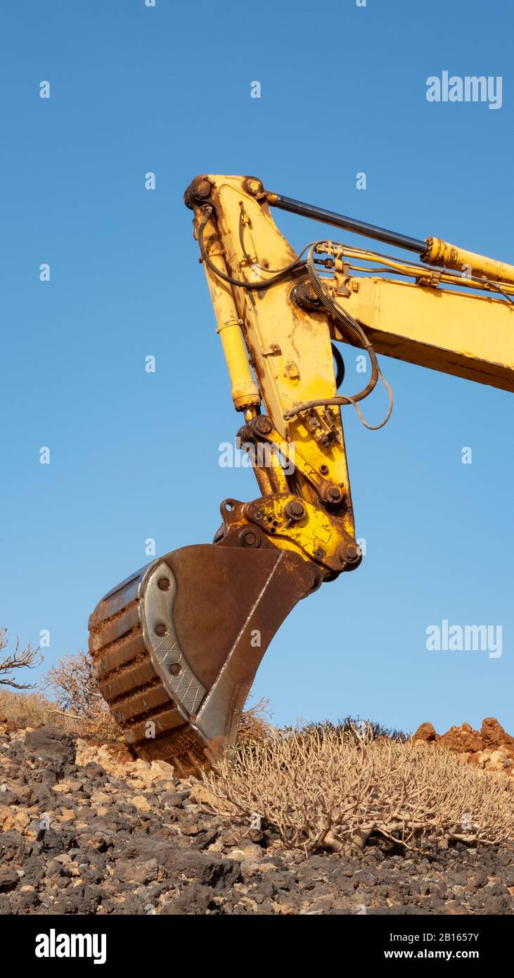 Construction excavator arm performing leveling and terracing work for a ...