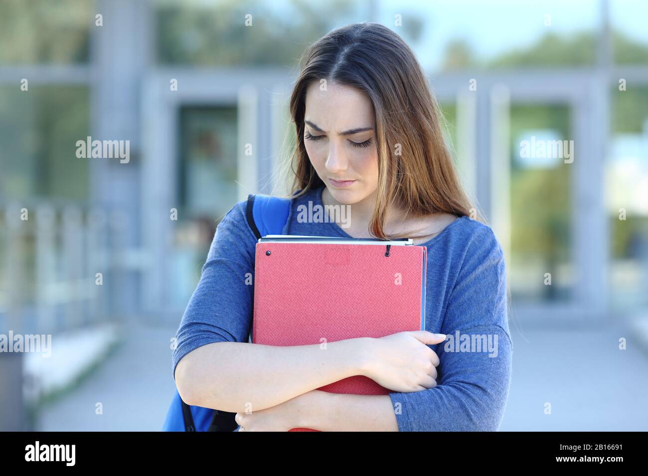 Sad student walking looking down complaining in an university campus ...
