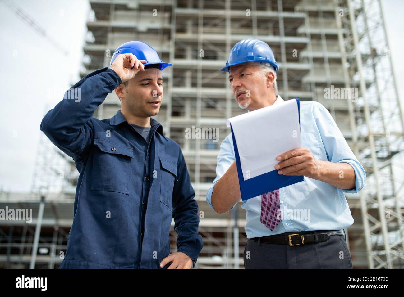 Engineer explaining a drawing to a worker Stock Photo - Alamy