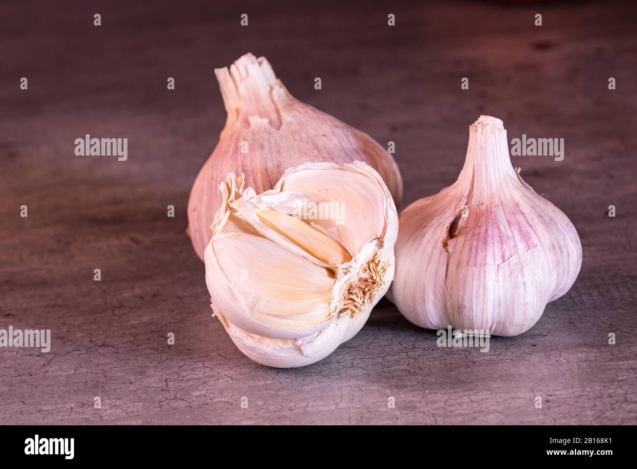 three large heads of pink garlic on a kitchen worktop Stock Photo - Alamy