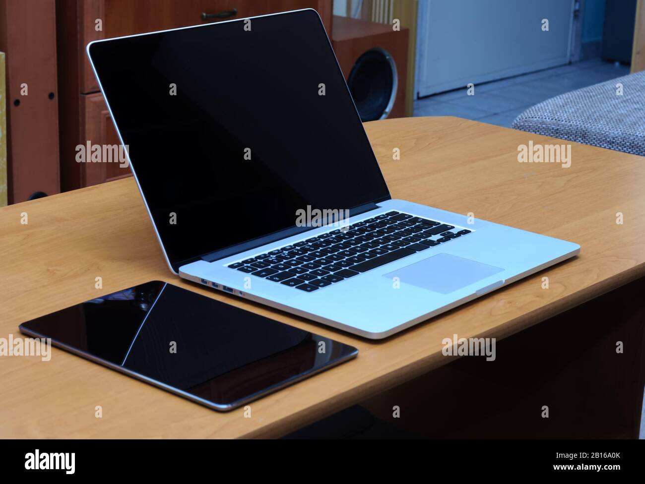 View on a laptop pc and a tablet on a desk in a home office environment ...