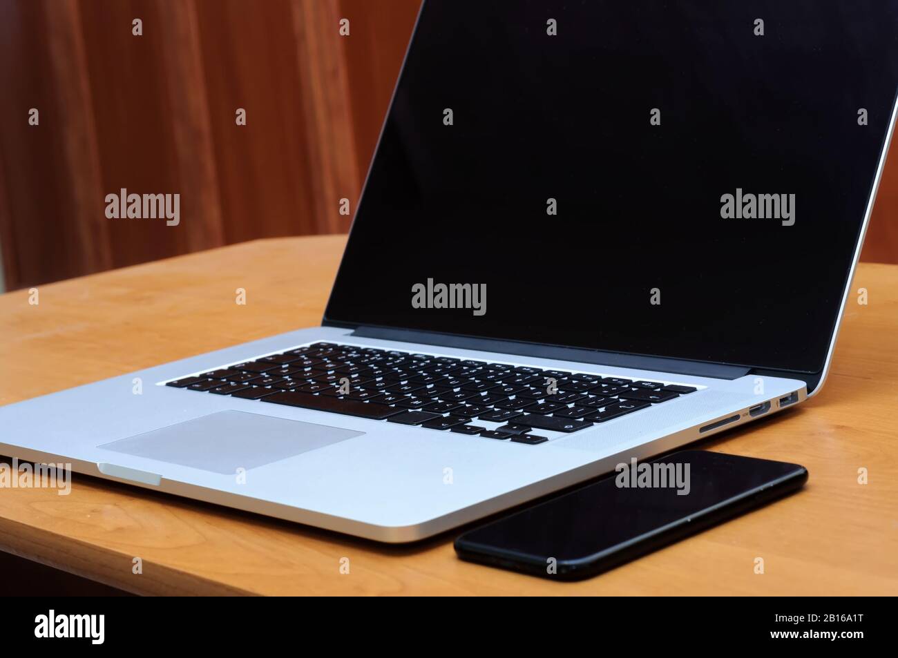 View on a laptop pc and a smartphone on a desk in a home office ...