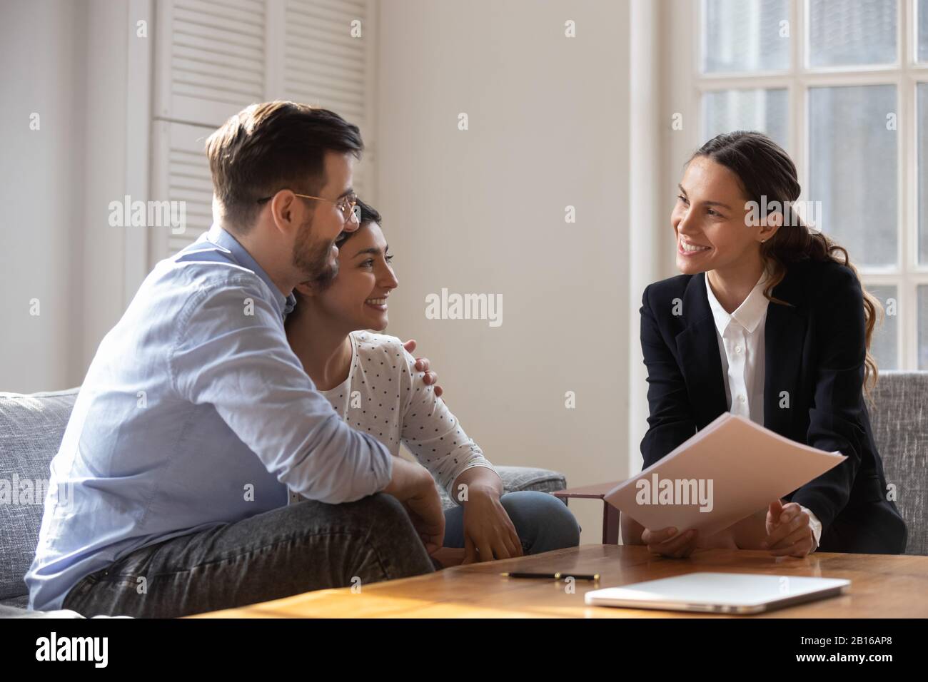 Client and banker seated on sofa discuss mortgage contract terms Stock ...