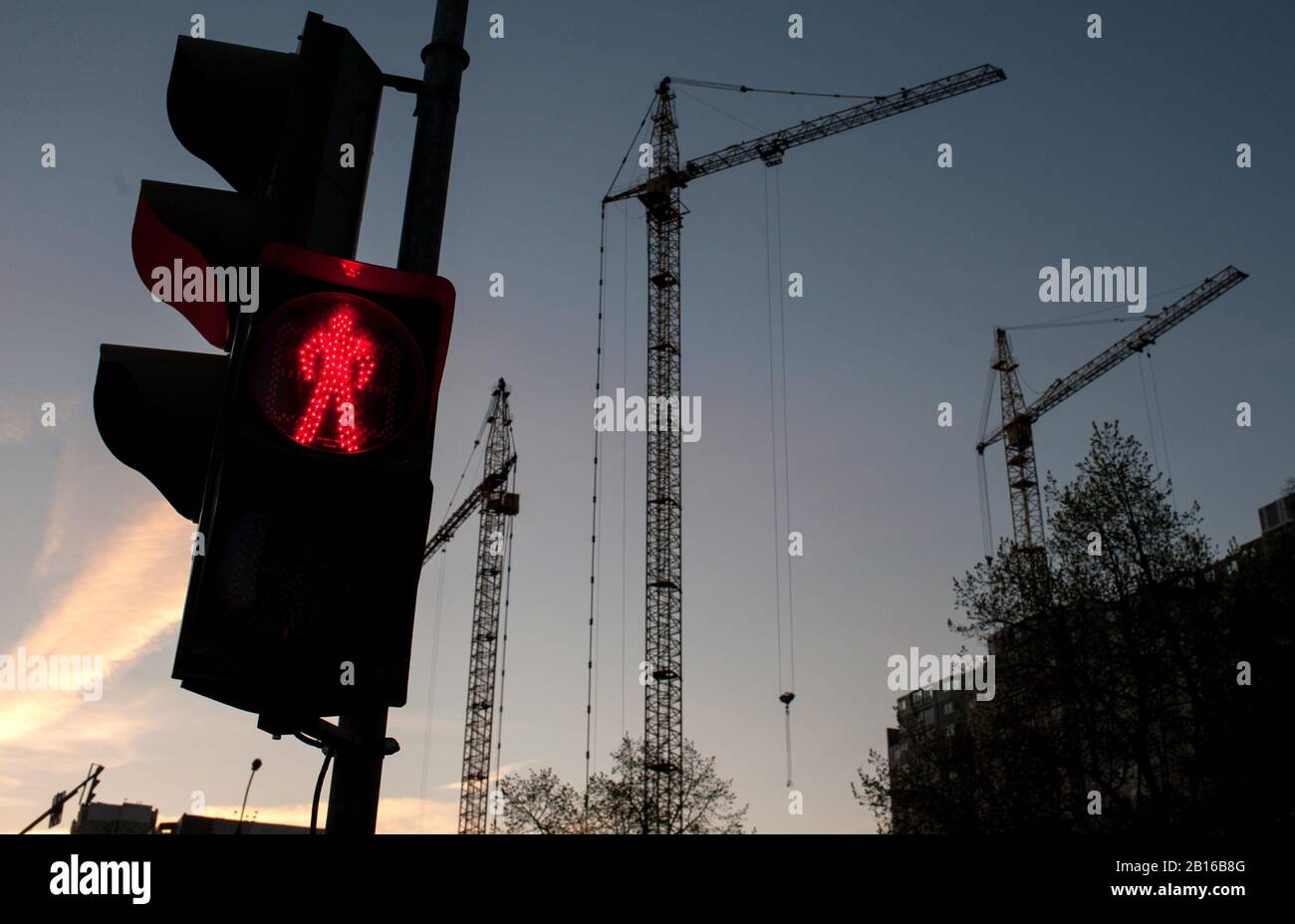 Red traffic light signal on the background of the construction of a ...