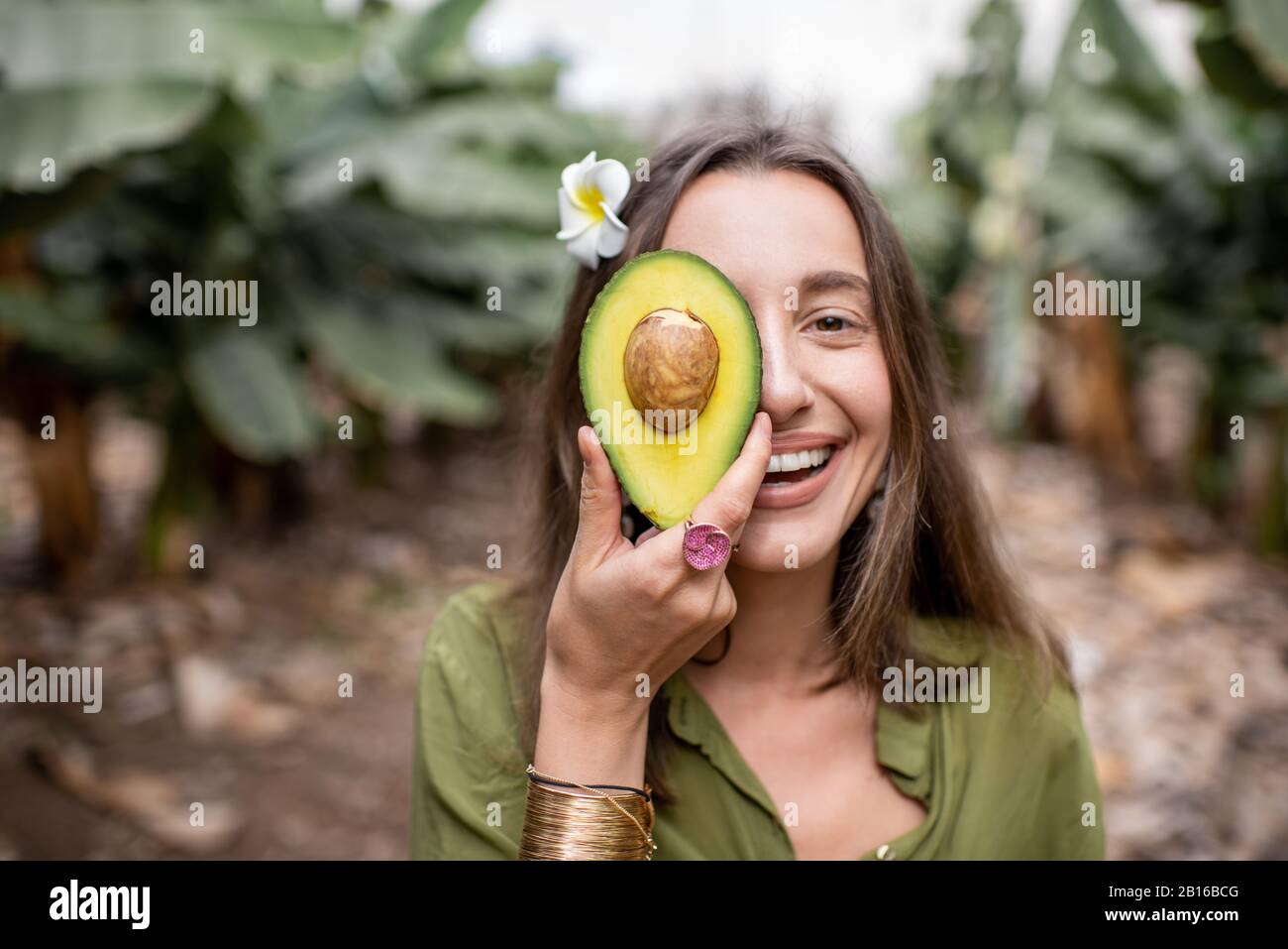 Closeup portrait of a young smiling woman hiding eyes with sliced ...