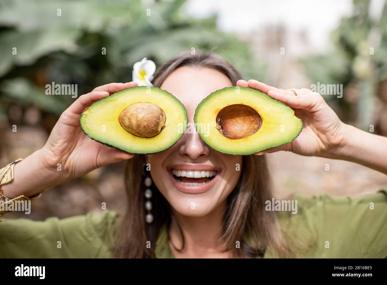 Closeup portrait of a young smiling woman hiding eyes with sliced ...