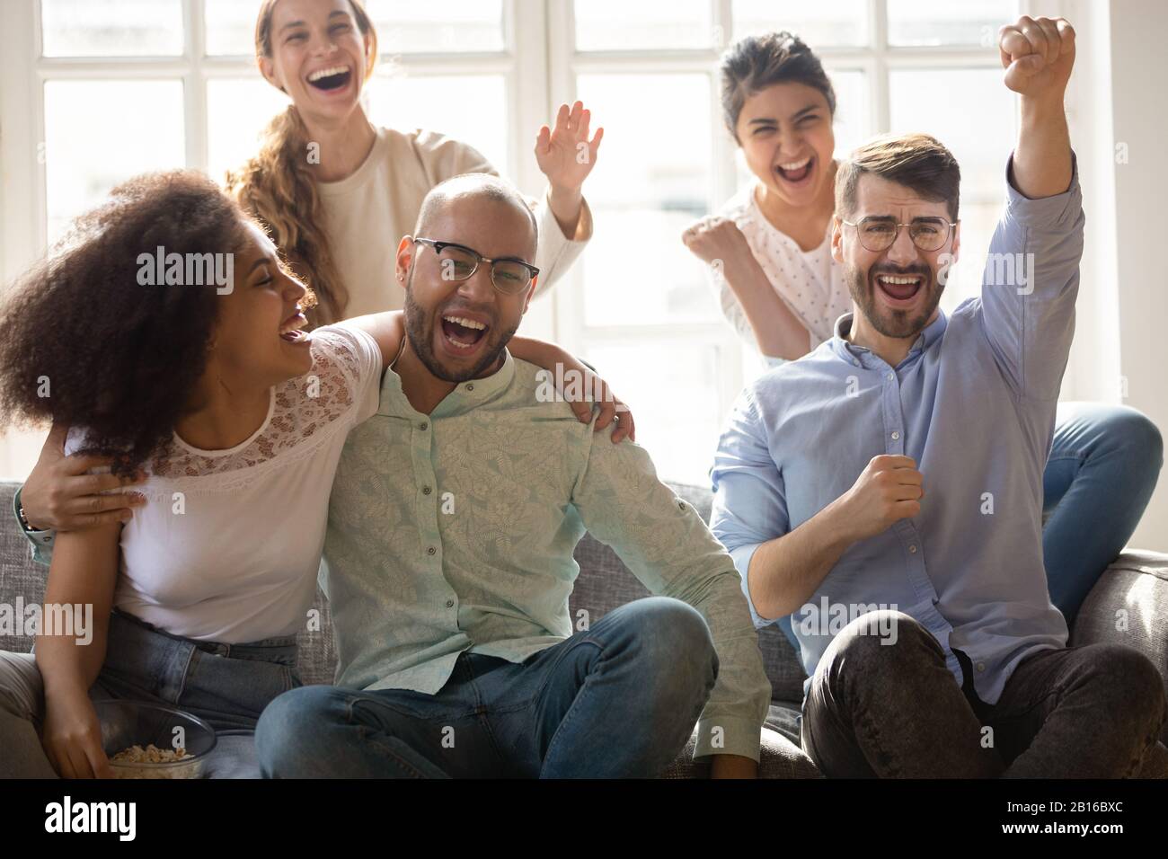 Excited overjoyed friends shouting with joy celebrating sport team win ...