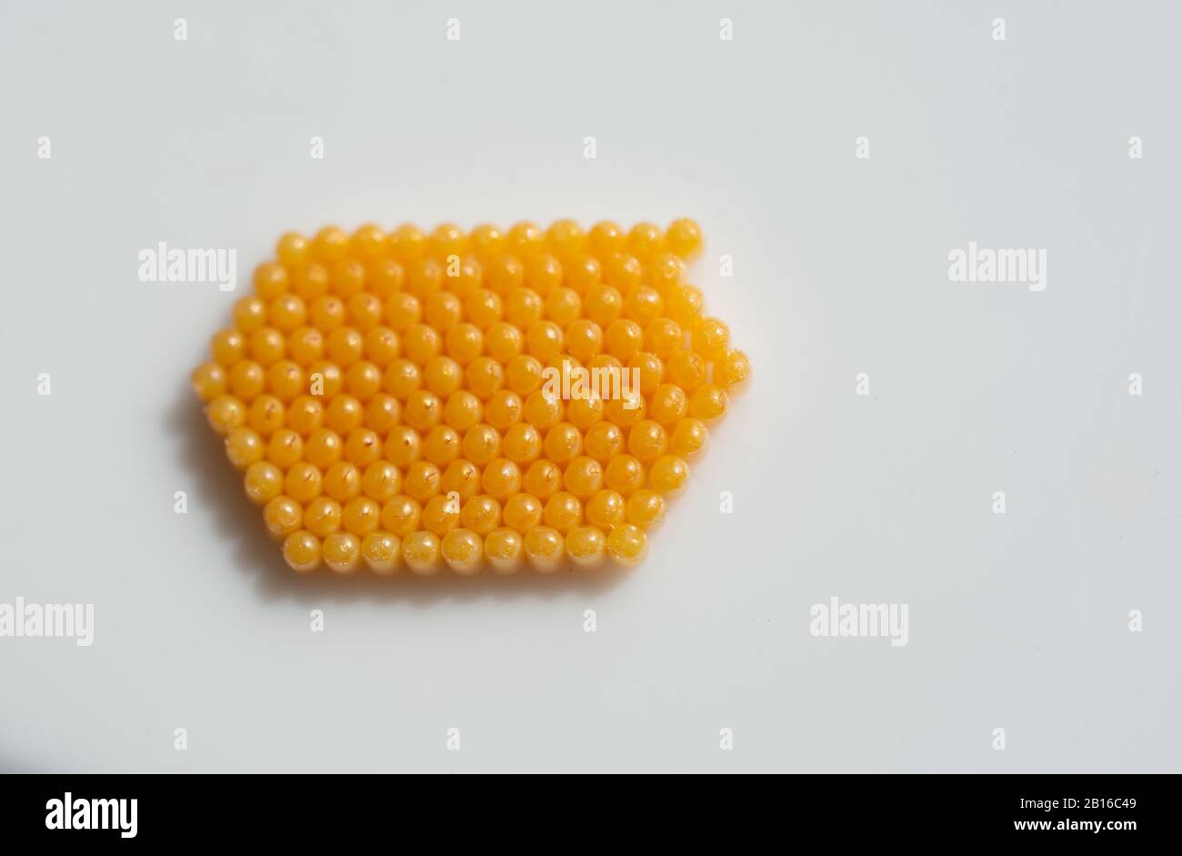 Yellow color insect eggs forming an almost perfect hexagon on a white ...