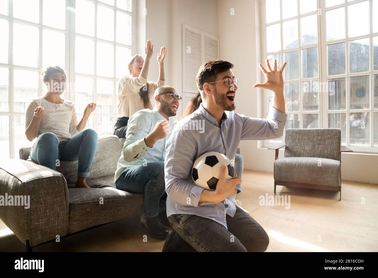Excited guy with friends celebrating favourite football team victory ...