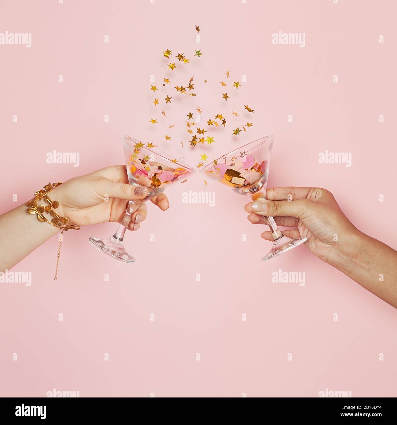 Celebration and holiday background. Two hands holding wine glasses with ...