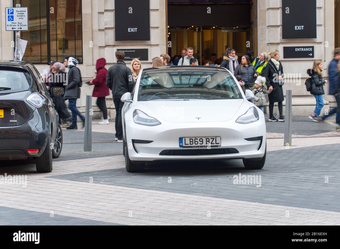 White Tesla Model 3 electric car parked outside science museum in ...