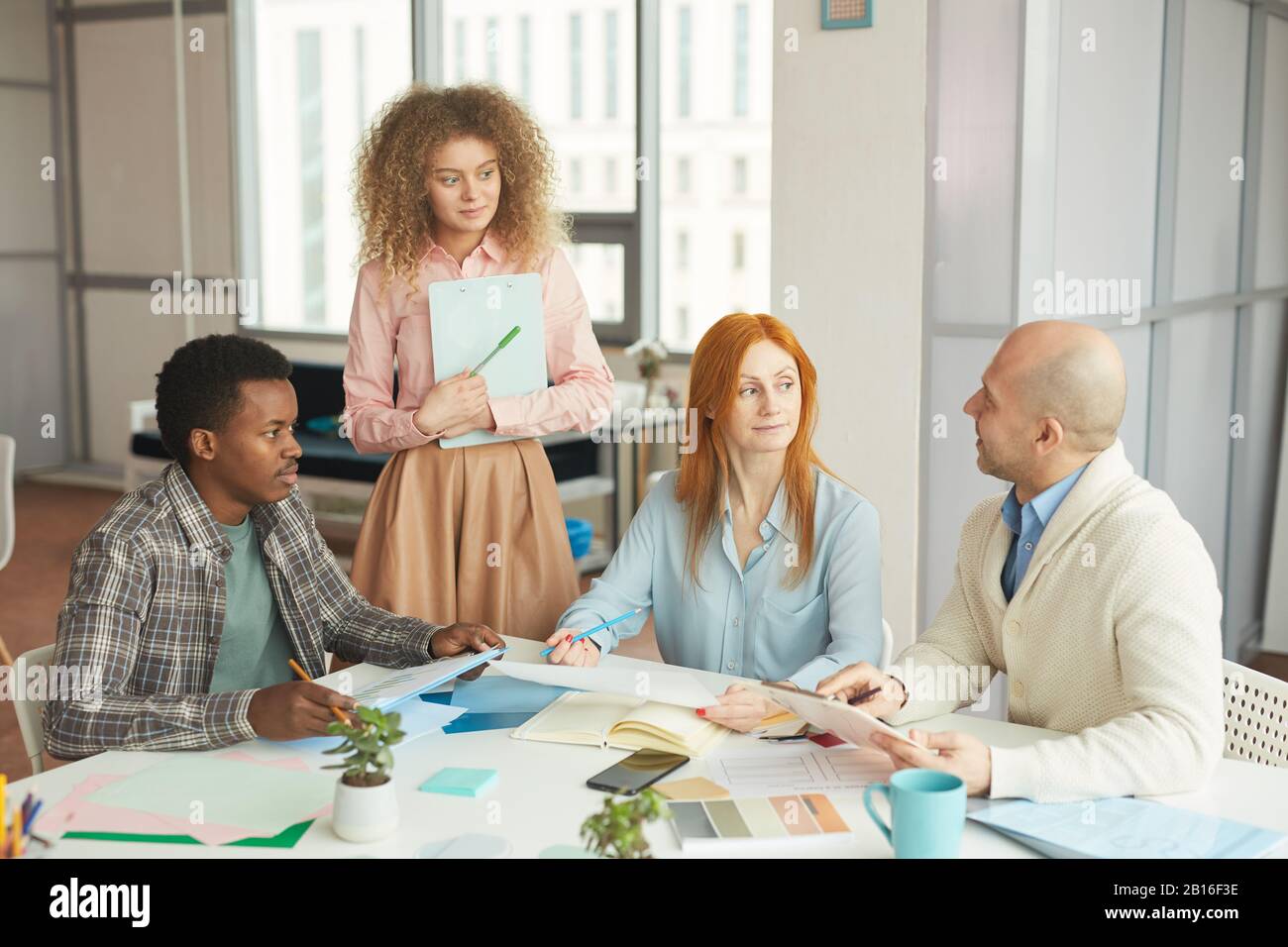 Portrait of diverse business team collaborating on creative project in ...