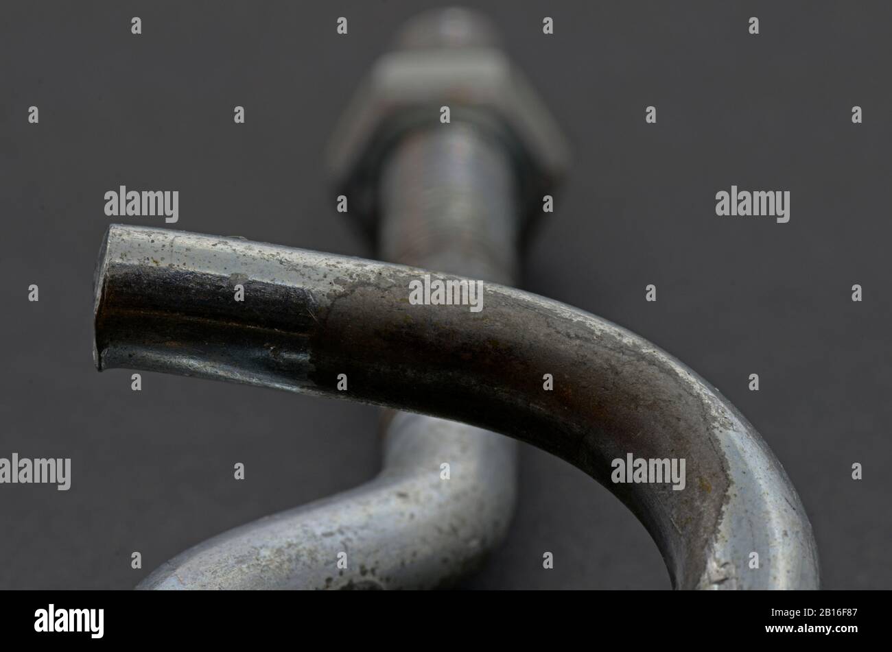 Steel pigtail screw hook on black background. Safety piece of hardware ...