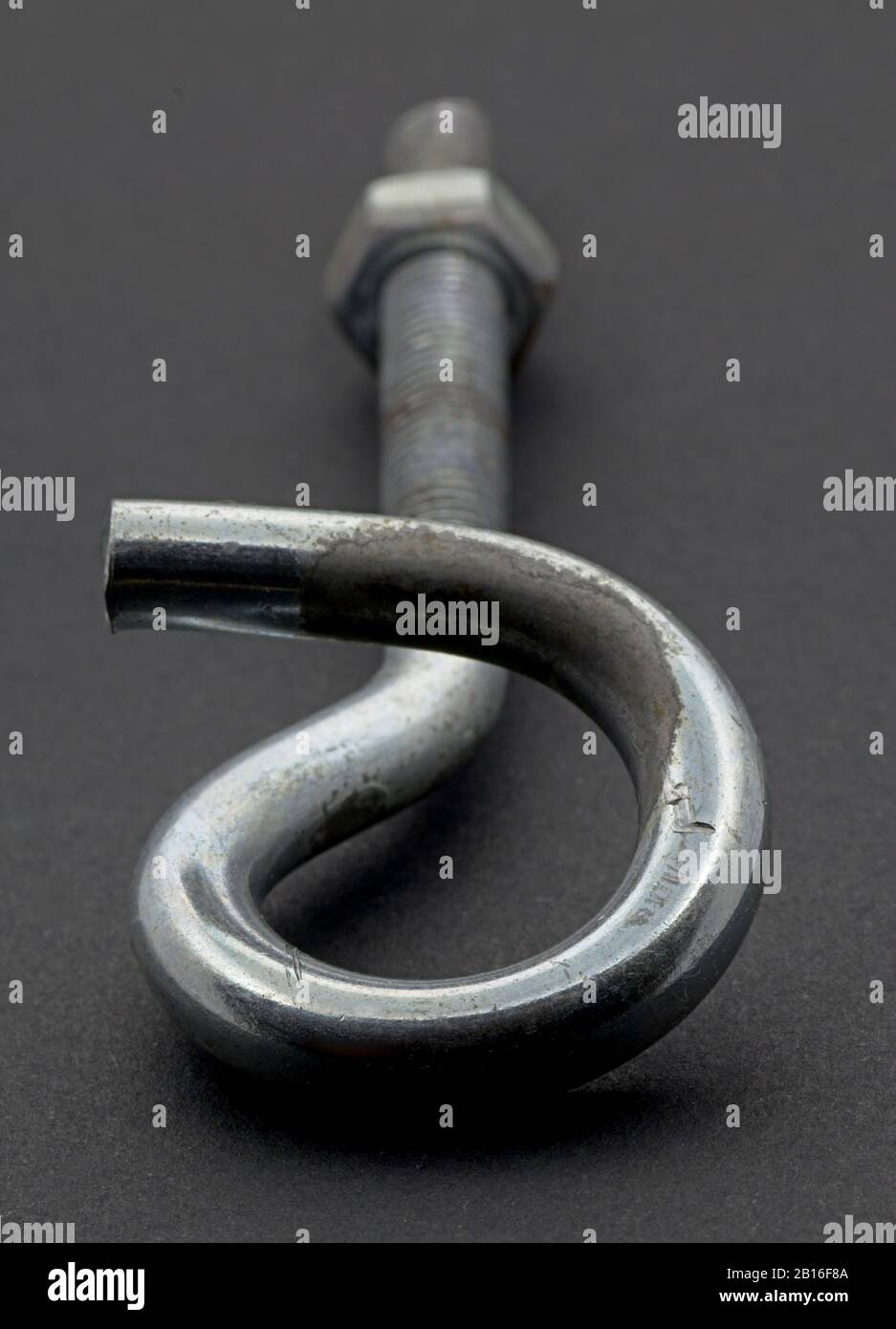 Steel pigtail screw hook on black background. Safety piece of hardware ...