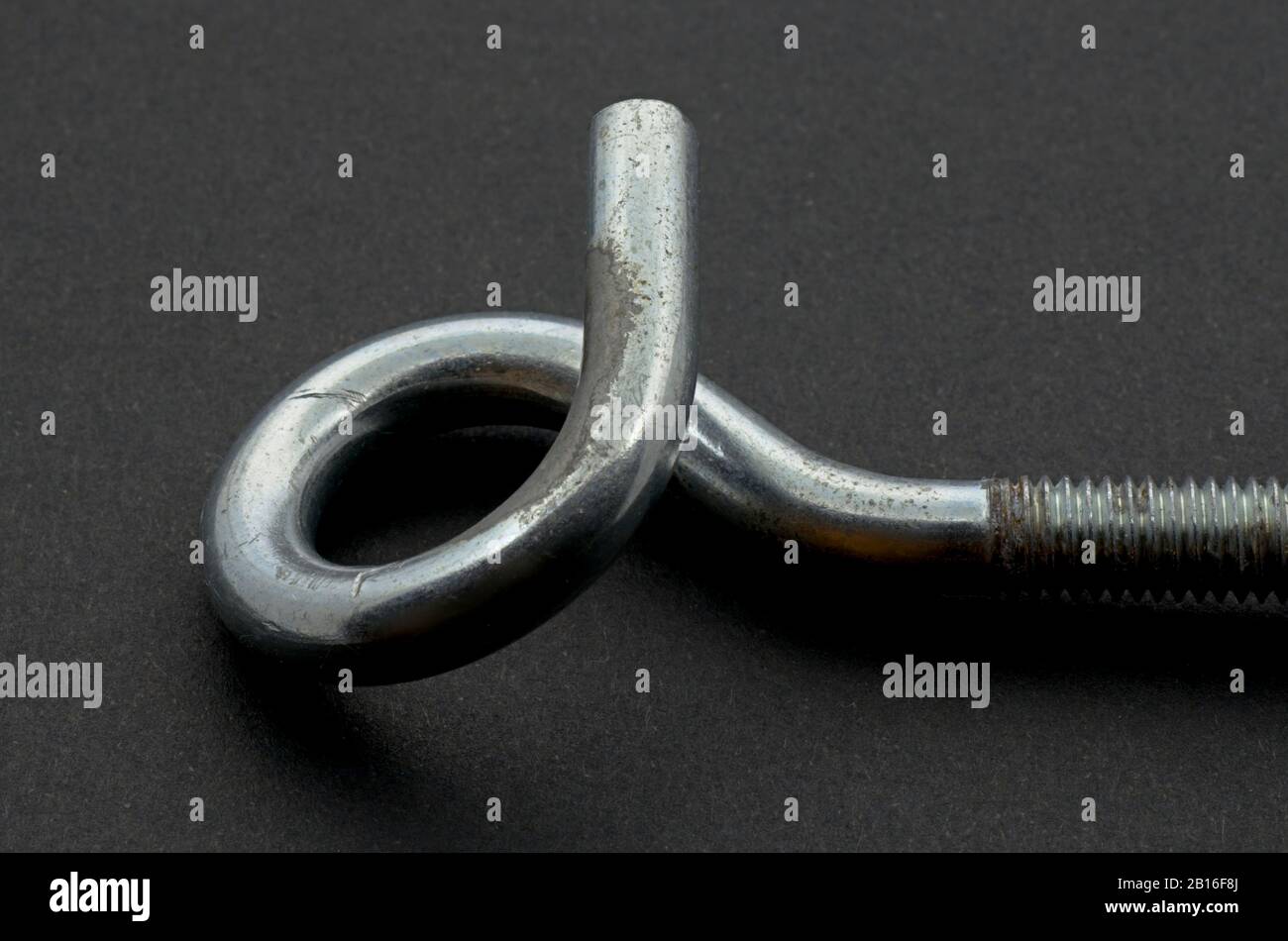 Steel pigtail screw hook on black background. Safety piece of hardware ...