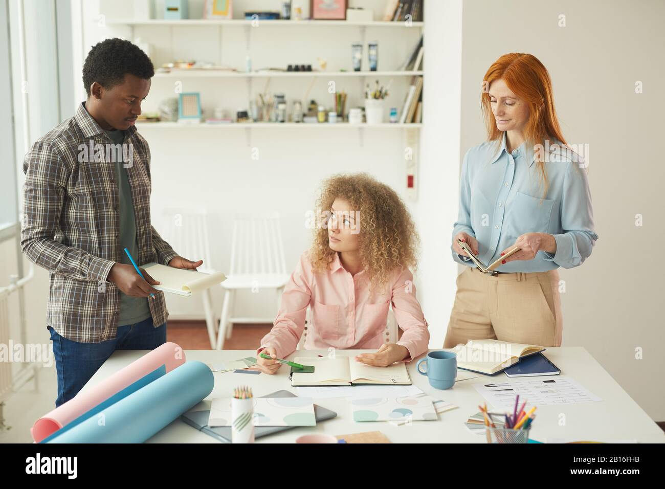 Portrait of creative business team collaborating on design project ...