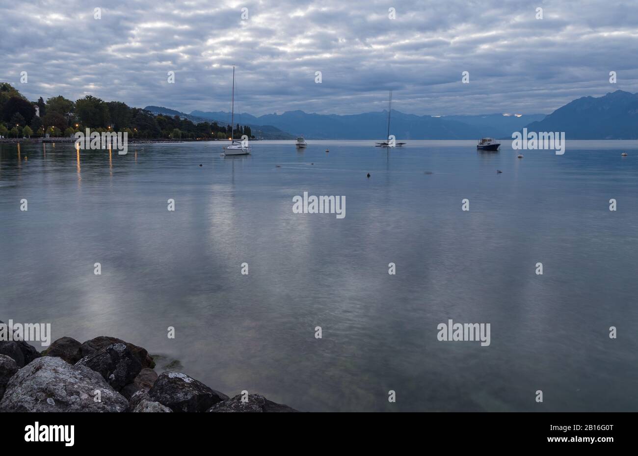 Water scape with mountains, clouds and boats on the lake Leman at the ...