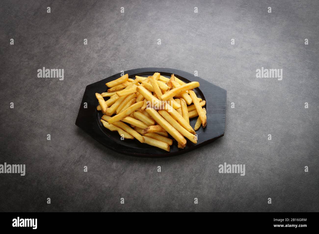 Tasty french fries on a gray background Stock Photo - Alamy