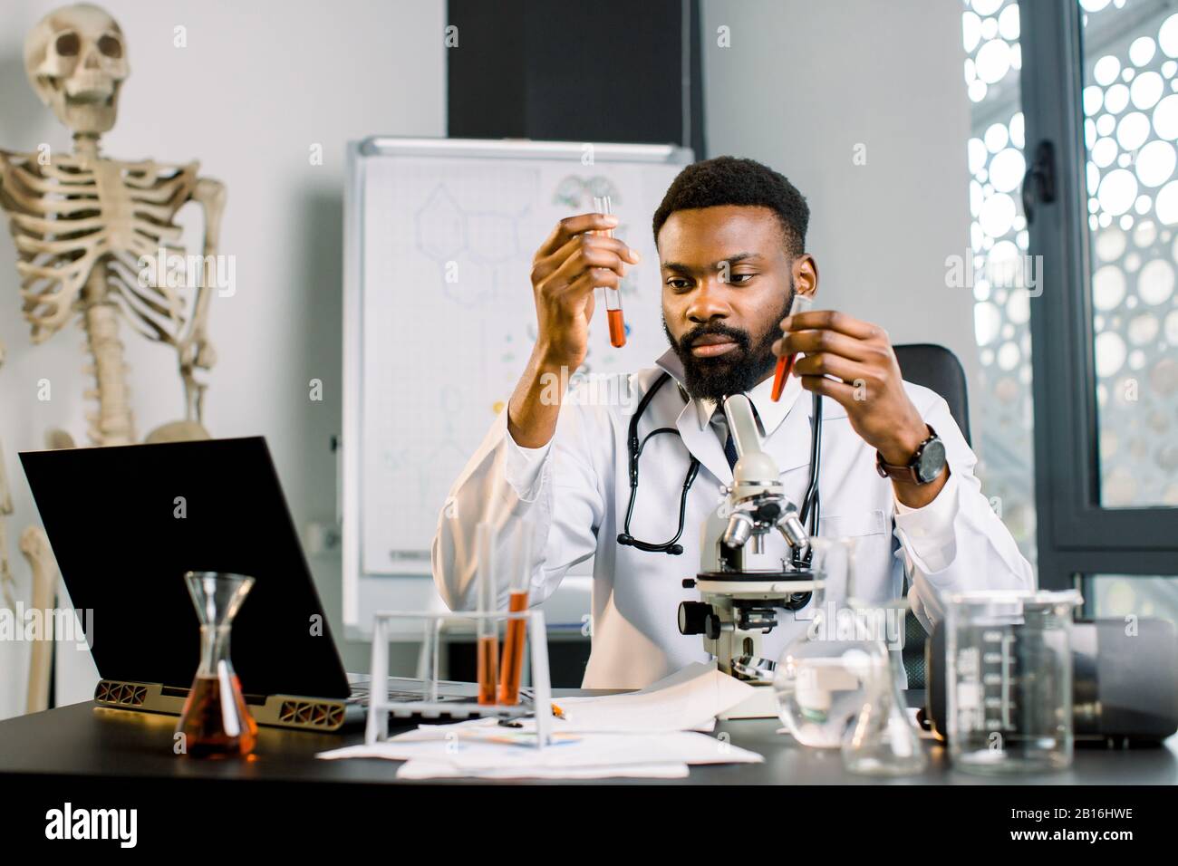 African man scientist, doctor, student works with test tubes in ...
