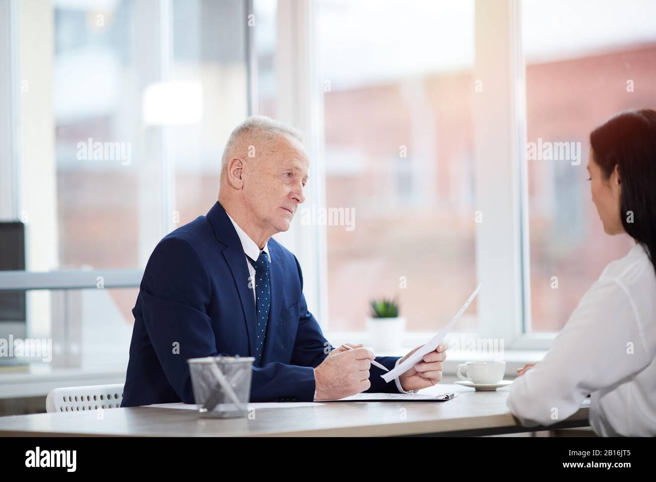 Side view portrait of successful senior businessman interviewing young ...
