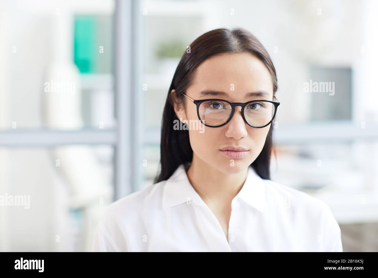 Head and shoulders portrait of young Asian businesswoman wearing ...
