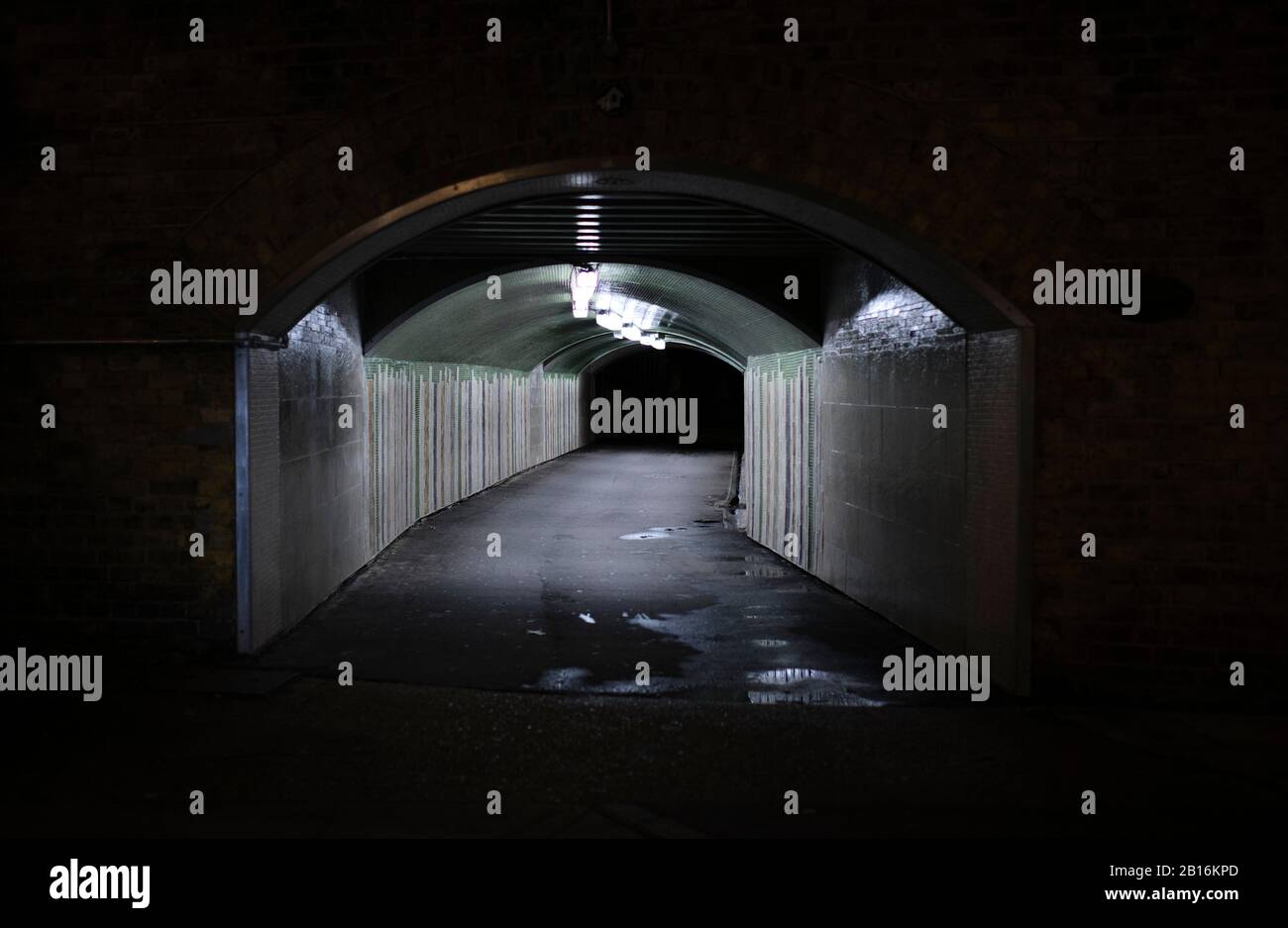 Badly lit pedestrian underpass at night, intimidating urban environment ...