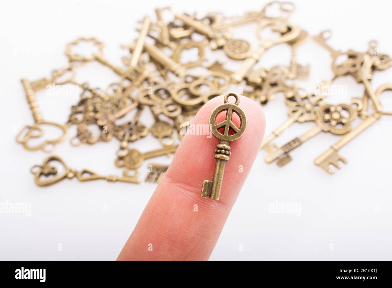 Peace symbol key in hand over and retro style metal keys Stock Photo ...
