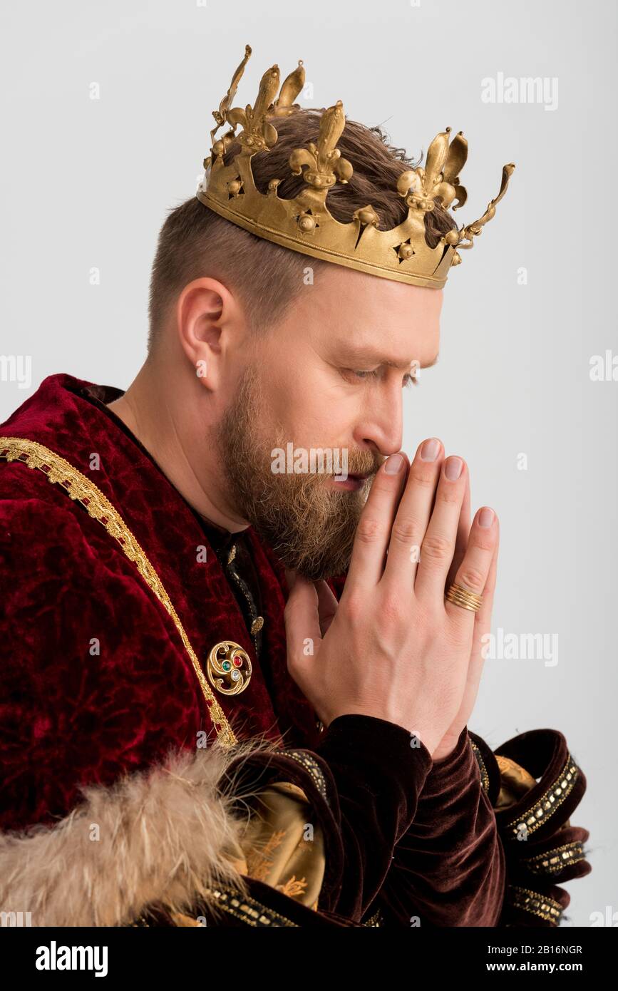 side view of king with crown praying isolated on grey Stock Photo - Alamy