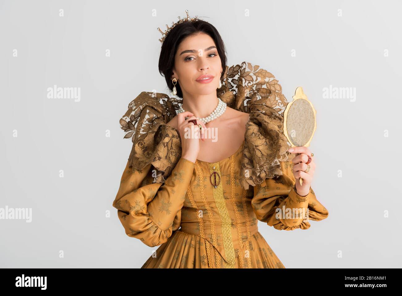 queen with crown holding mirror and looking at camera isolated on grey ...