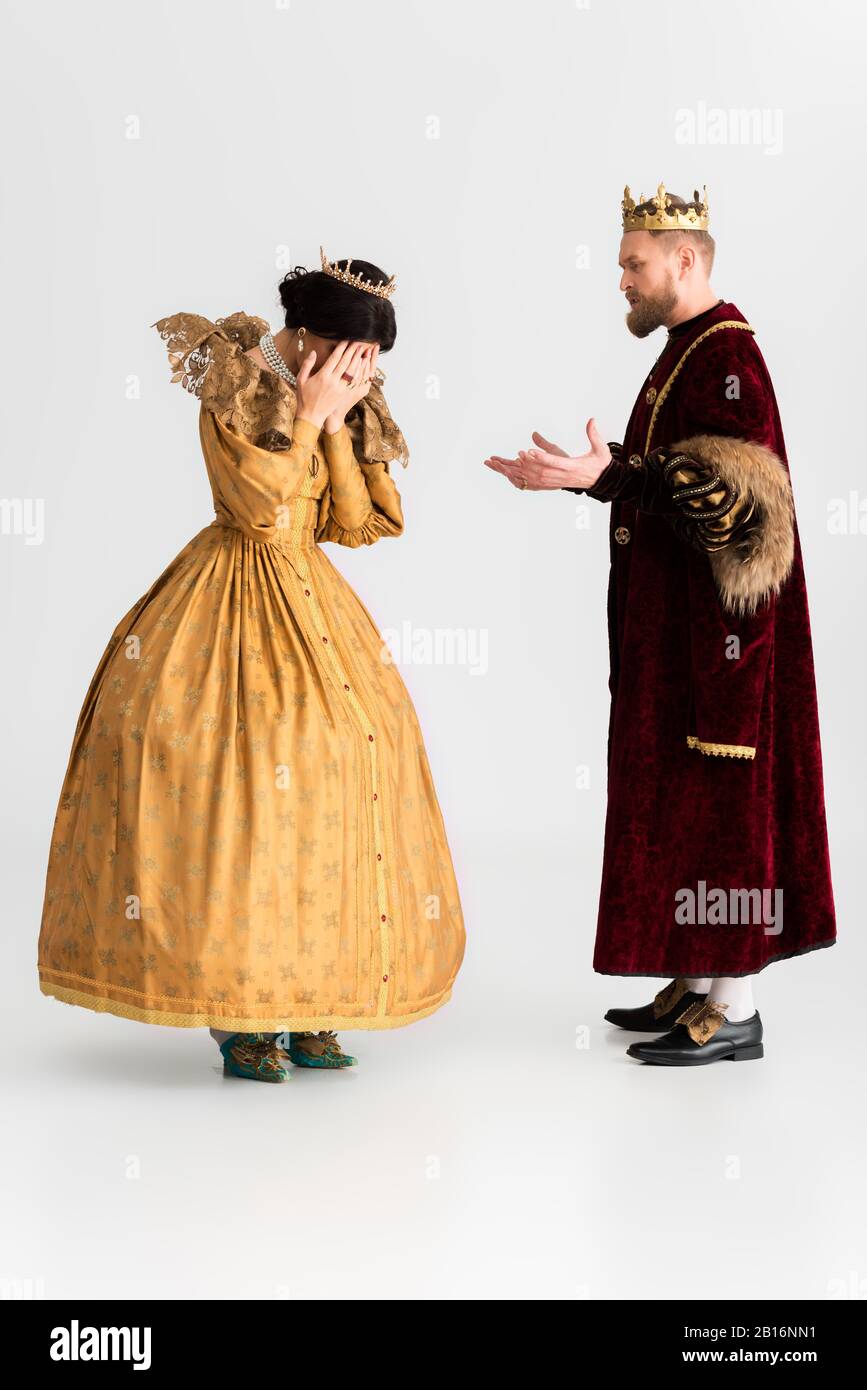 king with crown looking at crying queen on grey background Stock Photo ...