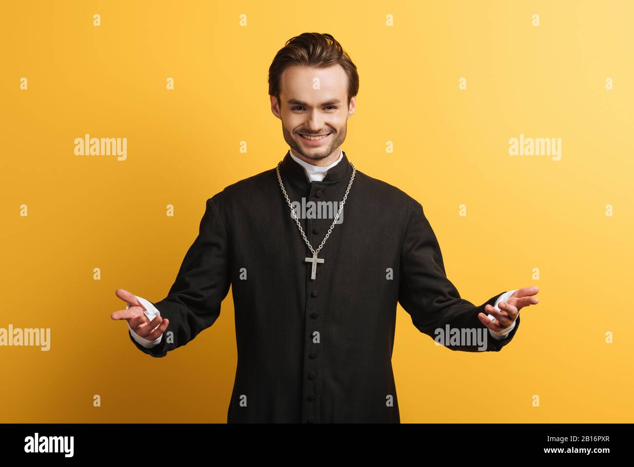smiling catholic priest standing with open arms and smiling isolated on ...