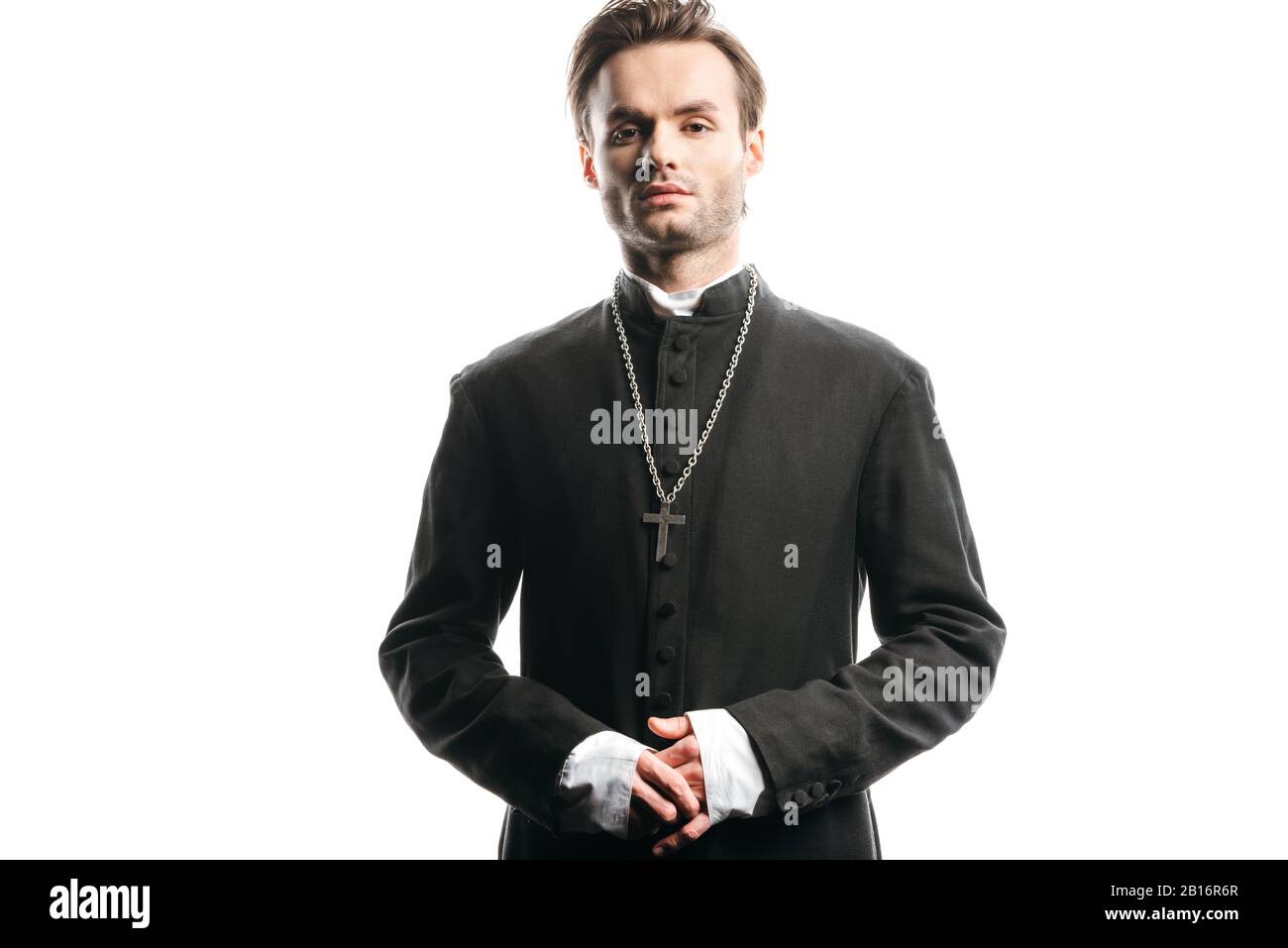 young, confident catholic priest looking at camera isolated on white ...