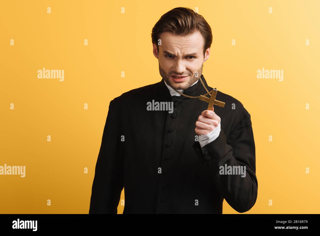 angry catholic priest showing holy christ while looking at camera ...