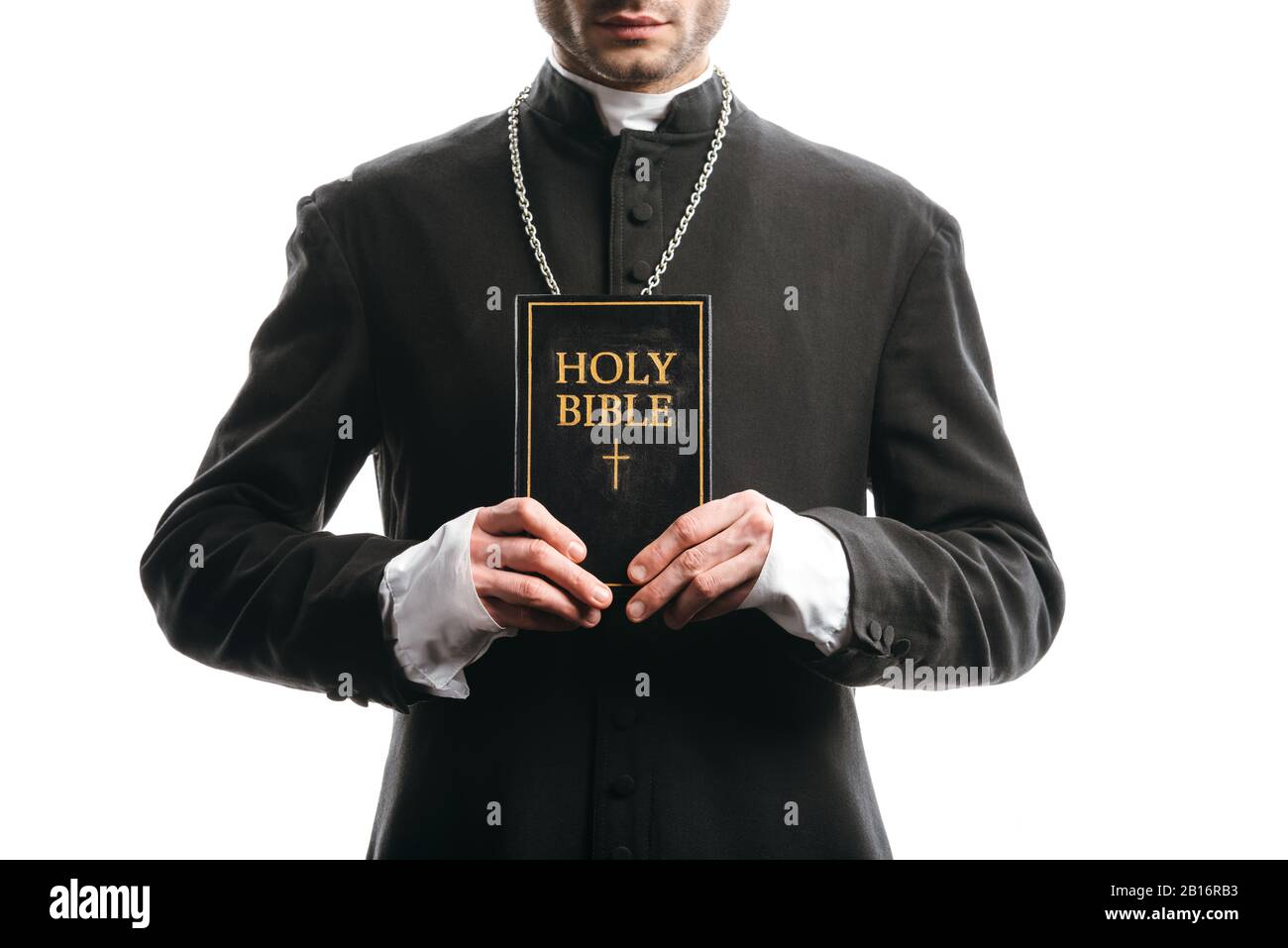 cropped view of catholic priest holding holy bible isolated on white ...