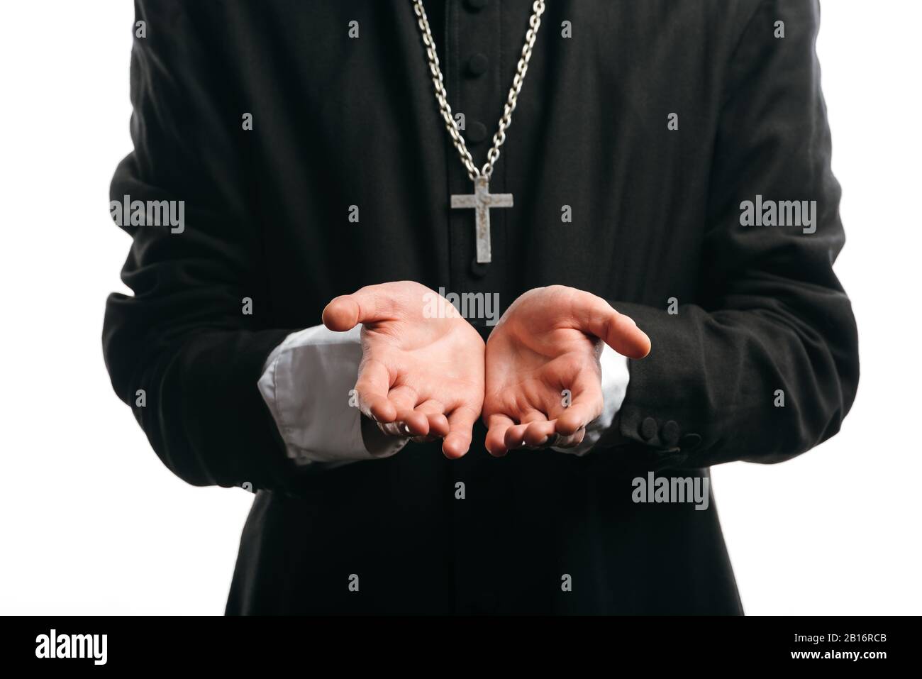 cropped view of catholic priest with silver cross on neck standing with ...