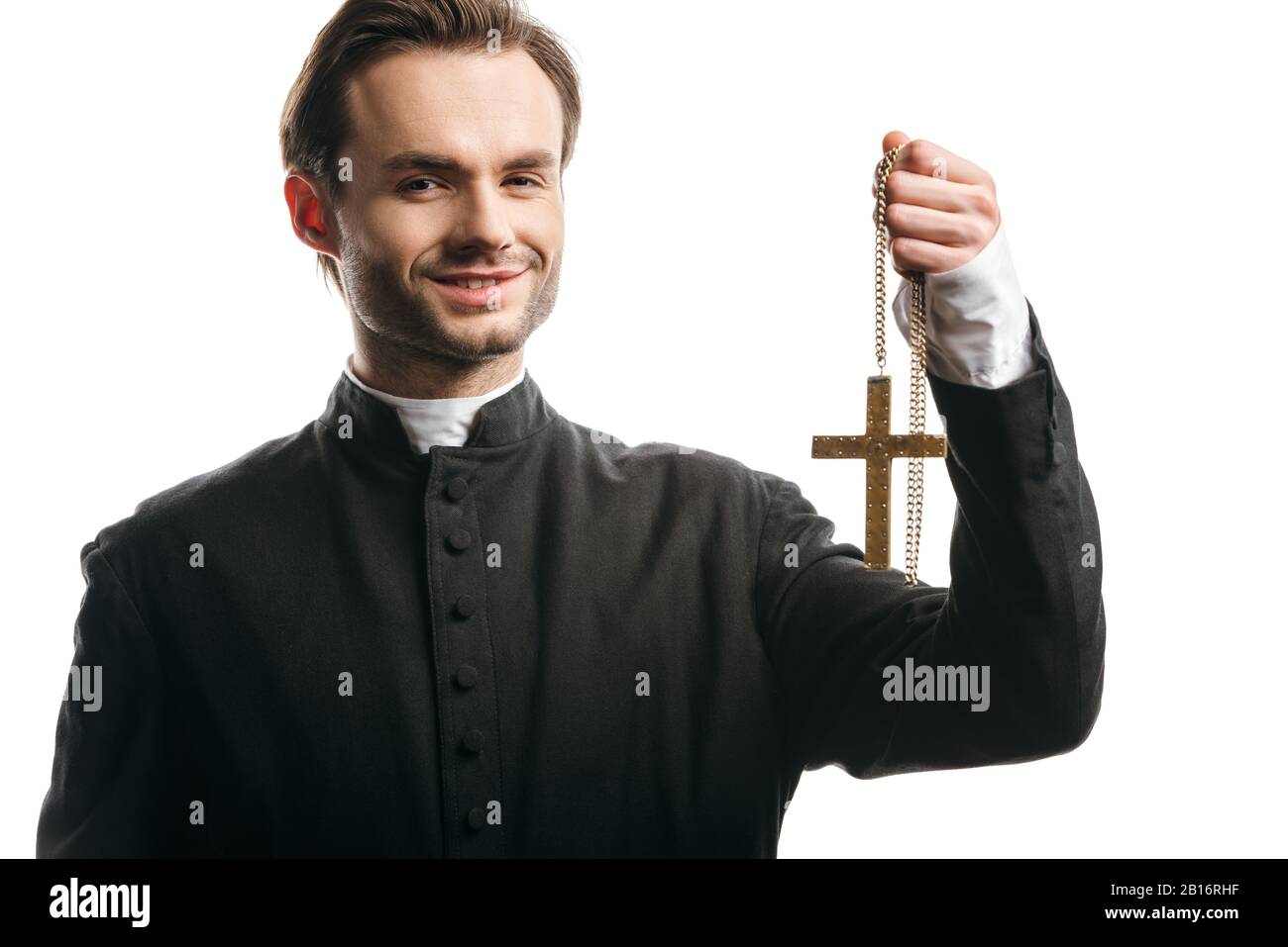 happy catholic priest holding golden cross while looking at camera ...