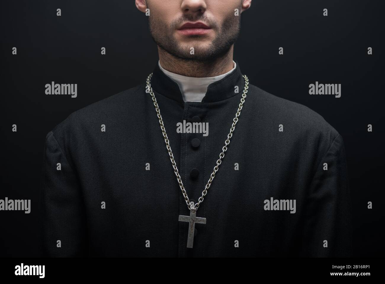partial view of catholic priest with silver cross on necklace isolated ...