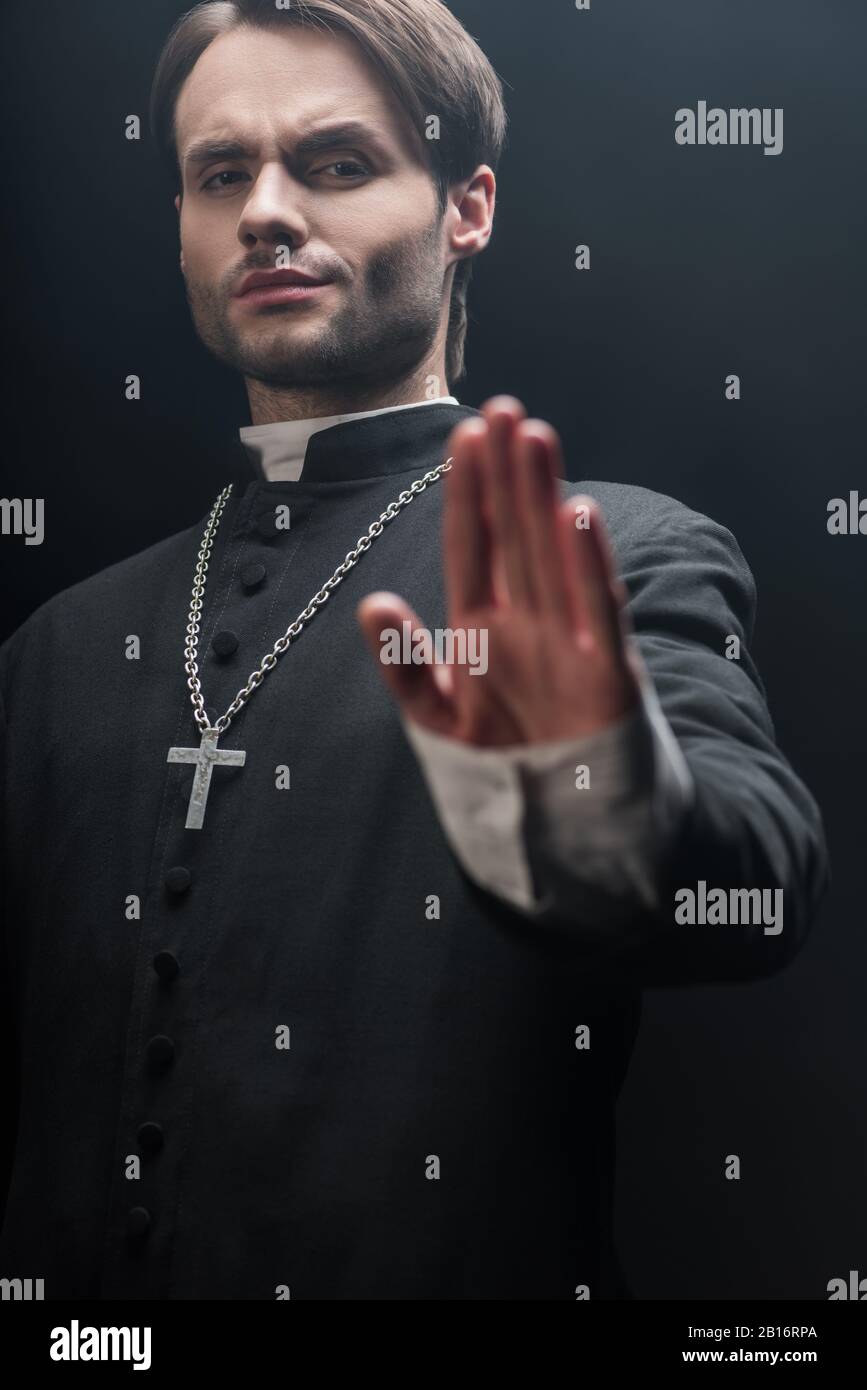 low angle view of strict catholic priest showing refuse gesture ...