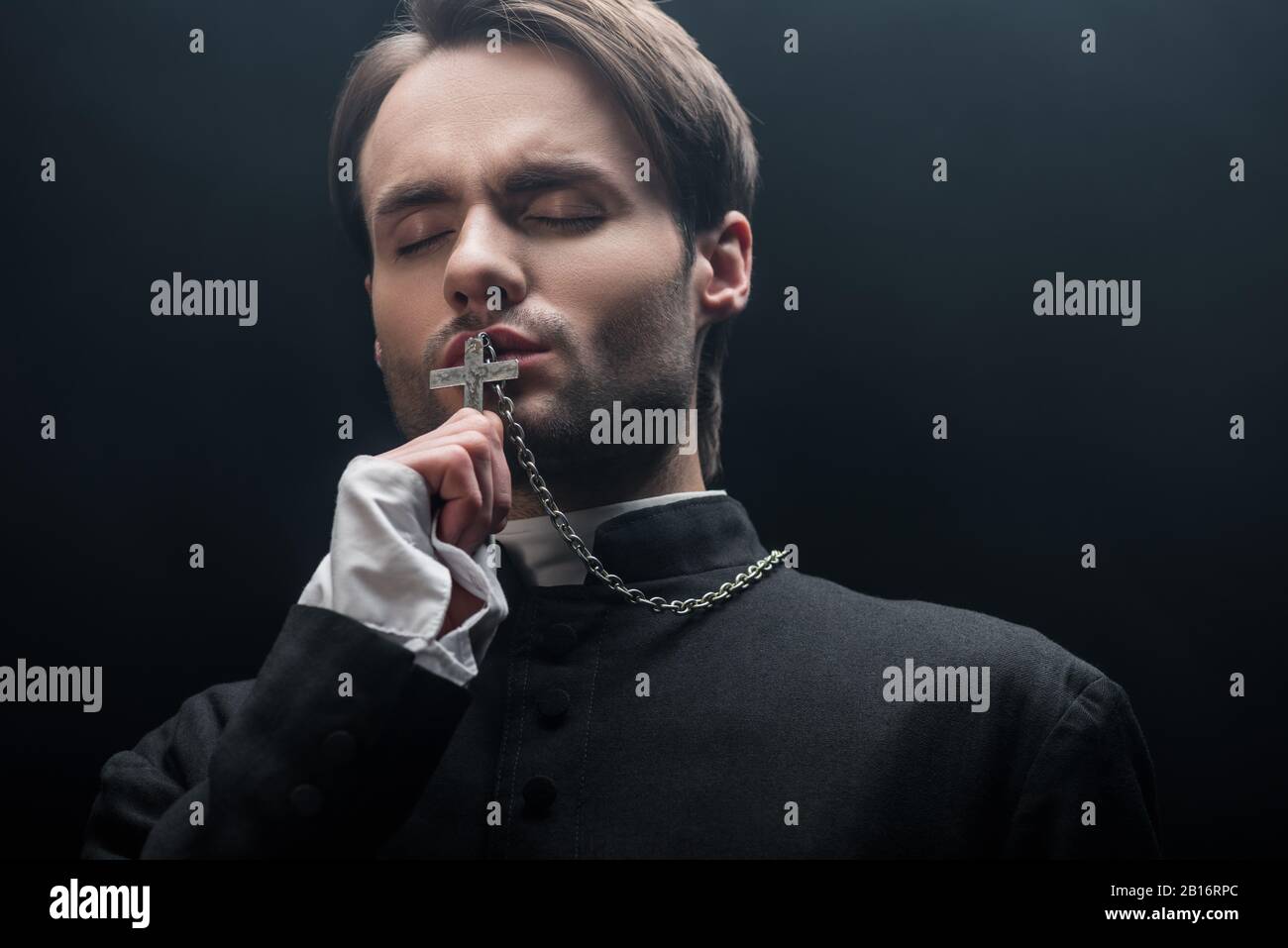 Priest kissing cross hi-res stock photography and images - Alamy